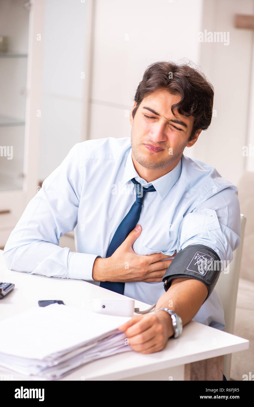 Man under stress measuring his blood pressure Stock Photo - Alamy