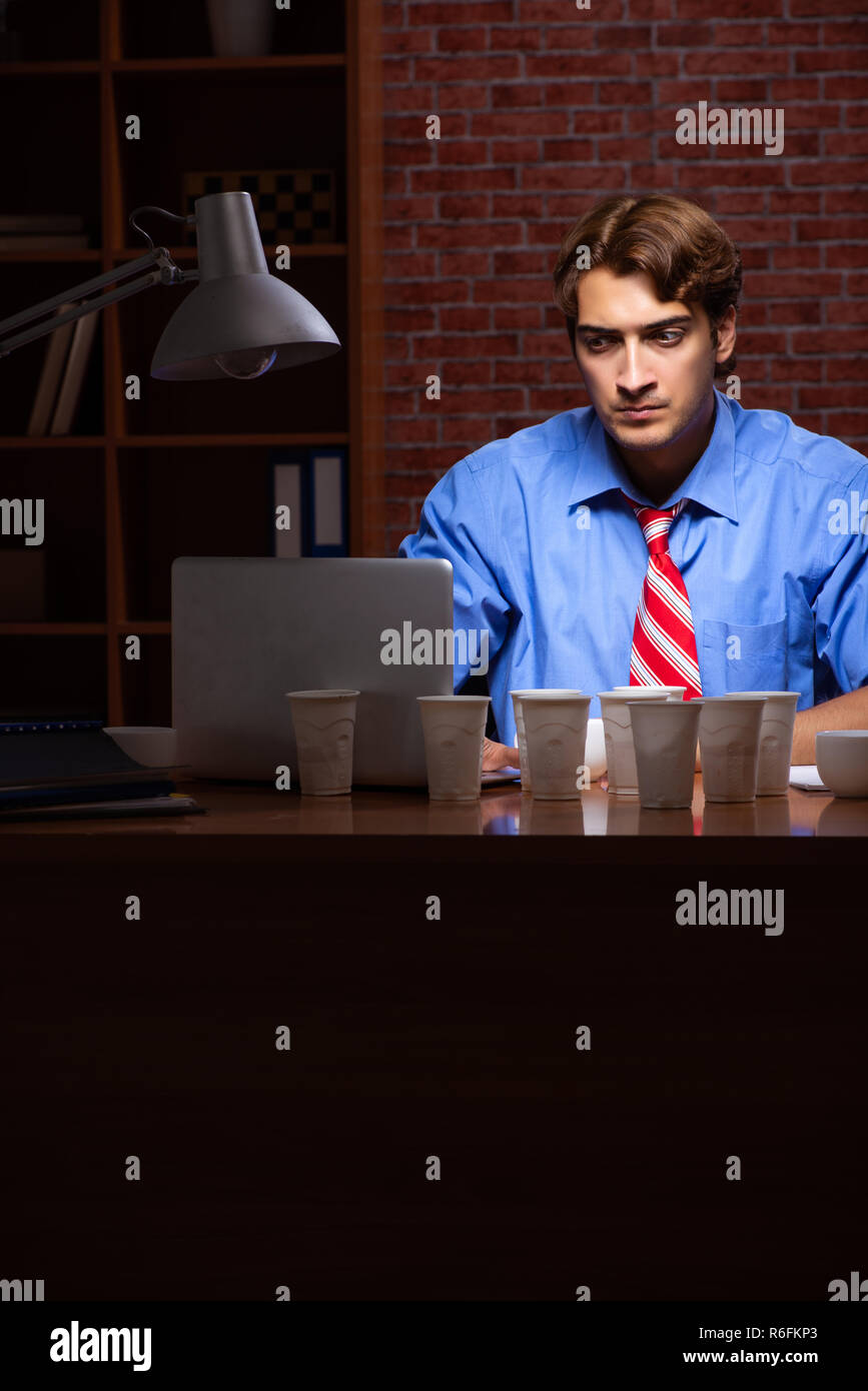 Young employee drinking coffee working at night shift Stock Photo - Alamy
