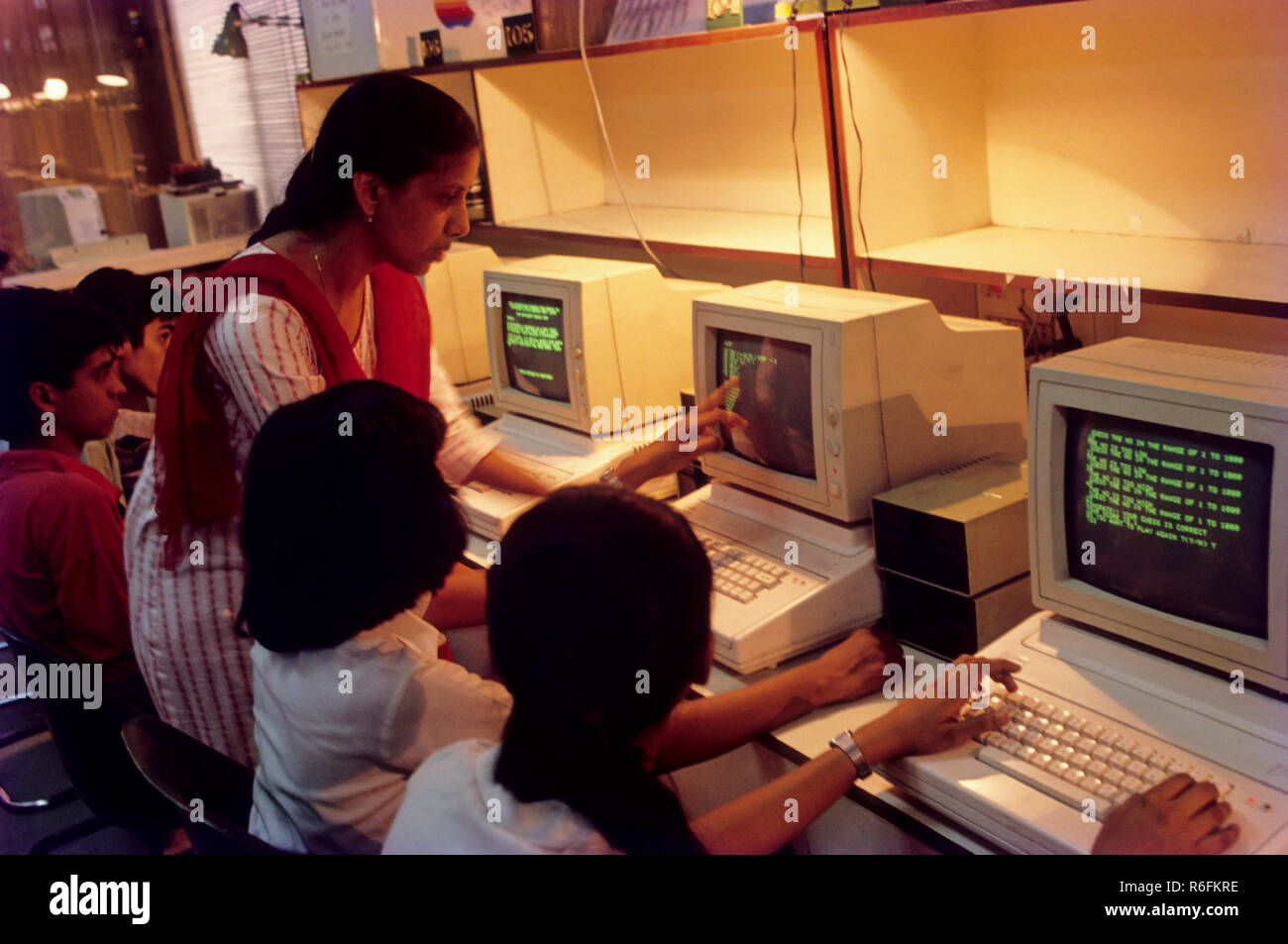 children learning computer and teacher teaching Stock Photo - Alamy