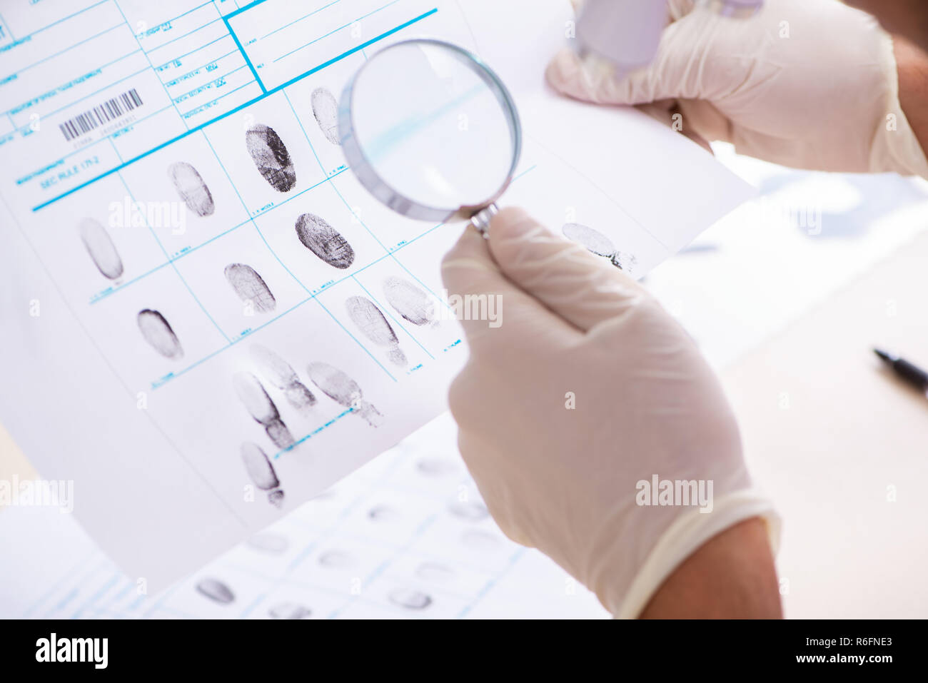 Forensic expert studying fingerprints in the lab Stock Photo - Alamy