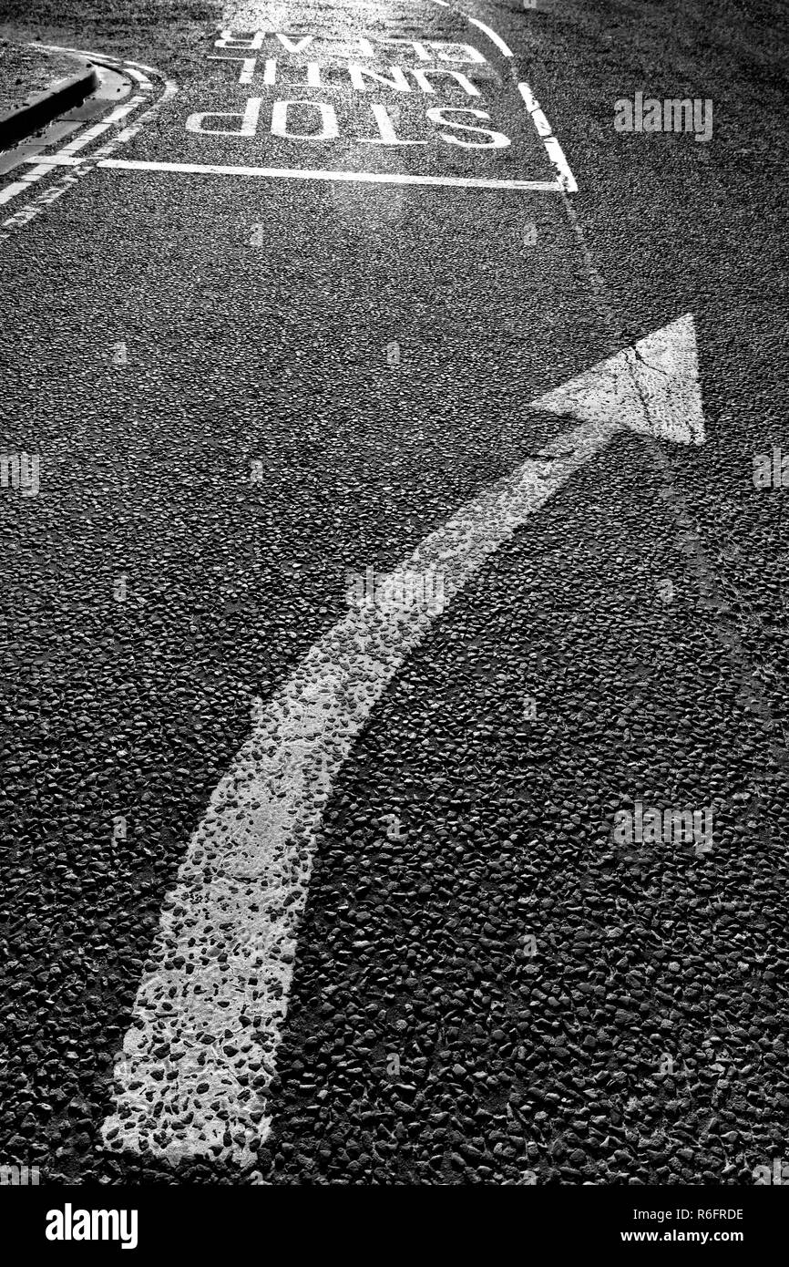 White road stop sign with large direction arrow Stock Photo - Alamy
