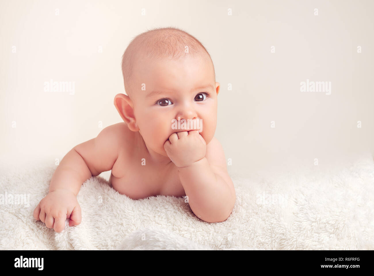 Small cute funny baby infant teething with face expression hands and ...