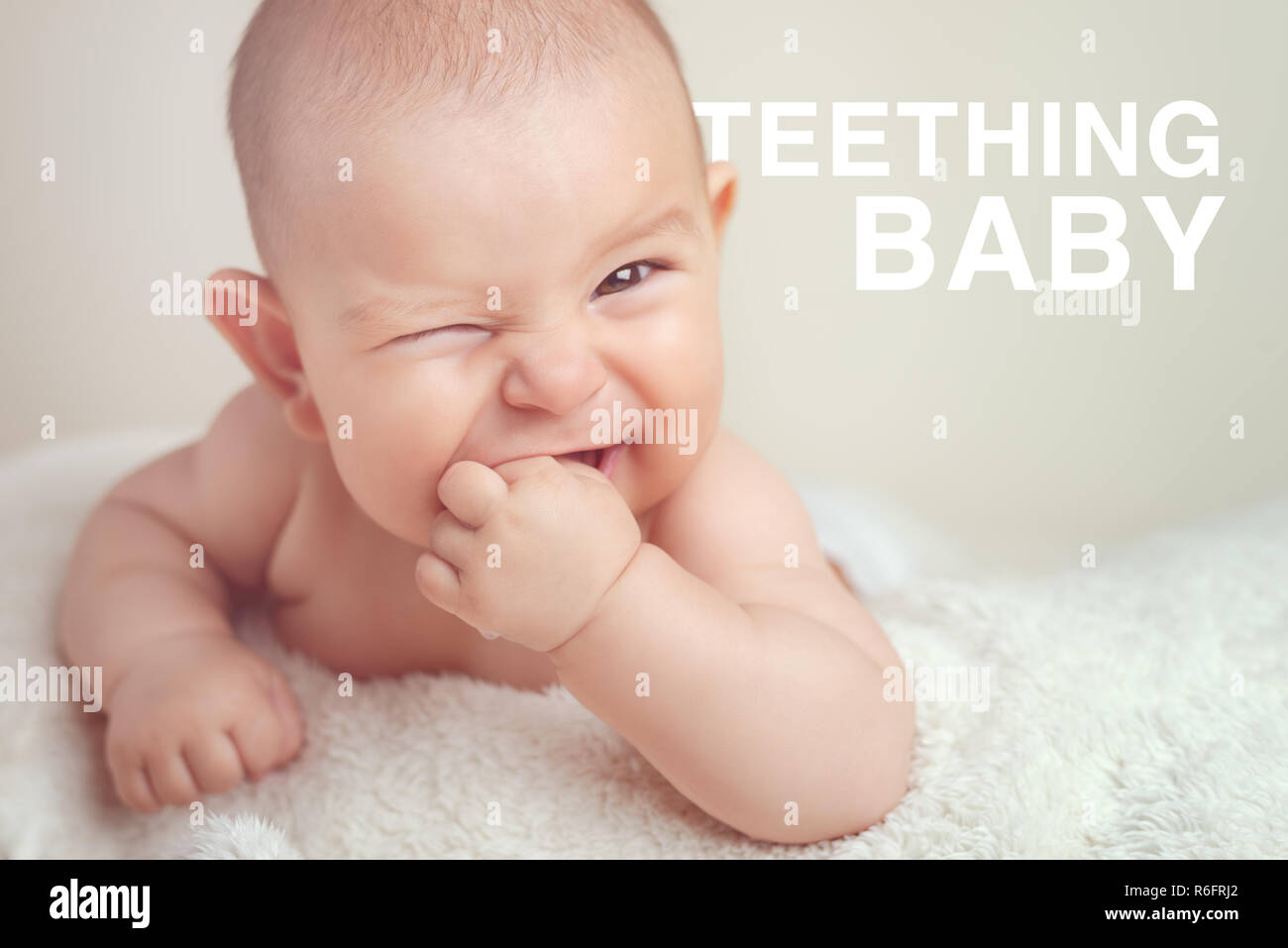 Small cute funny baby infant teething with face expression hands and ...