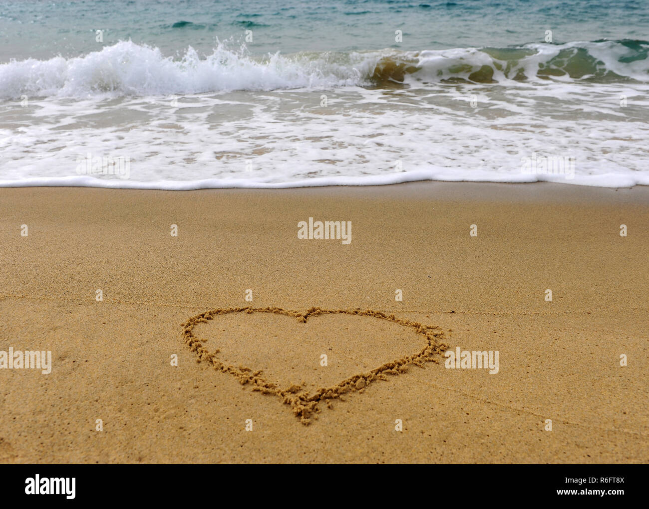 Heart shape handwriting sign on the sand beach Stock Photo - Alamy