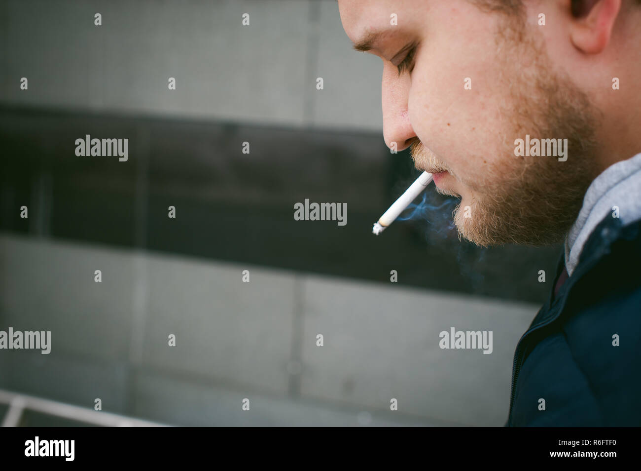 Portrait of a man with a beard with a mustache, smoking a cigarette ...