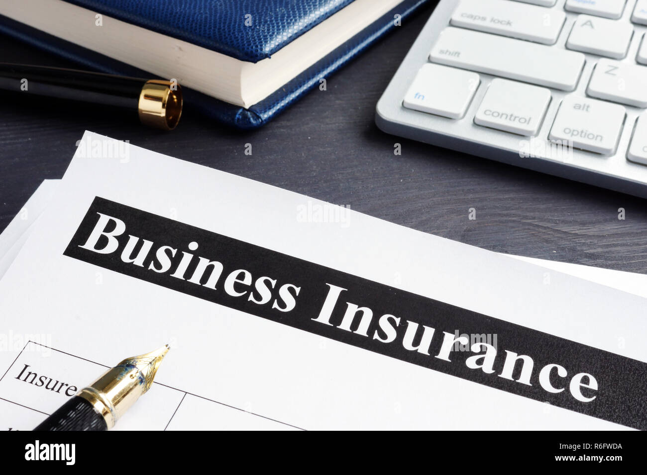 Business insurance policy and pen on a desk Stock Photo - Alamy