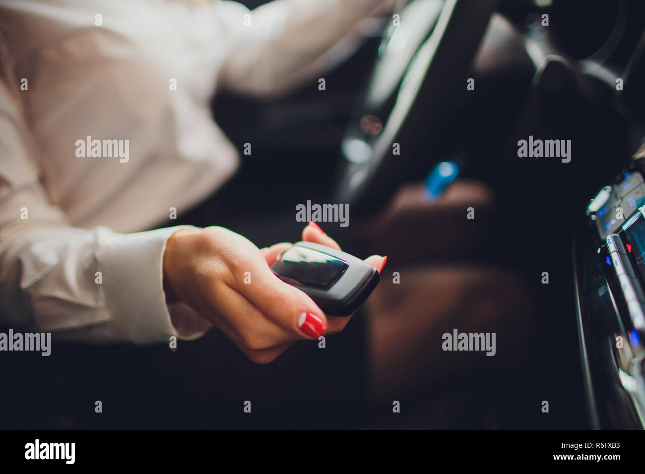 Female holding car keys with car on background Stock Photo - Alamy