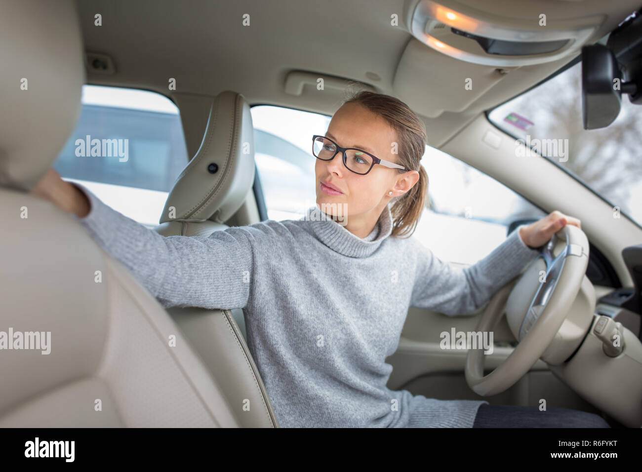 Woman driving a car - female driver at a wheel of a modern car, parking ...