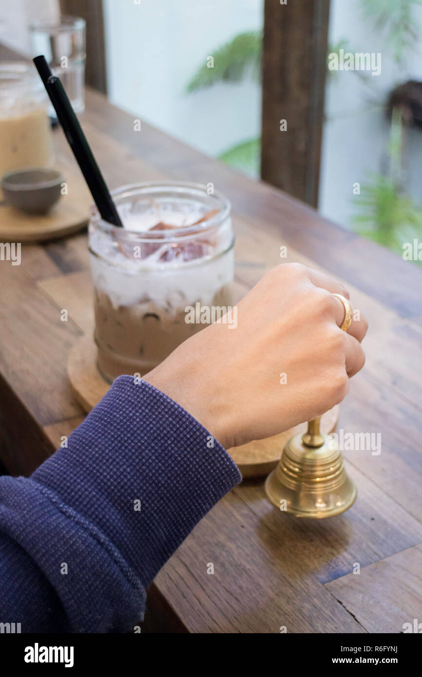 Hand on brass bell in coffee shop Stock Photo - Alamy