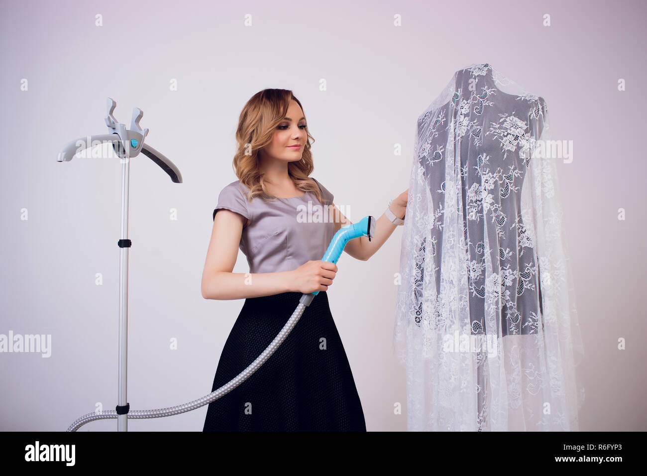 Women steaming dress in room Stock Photo - Alamy