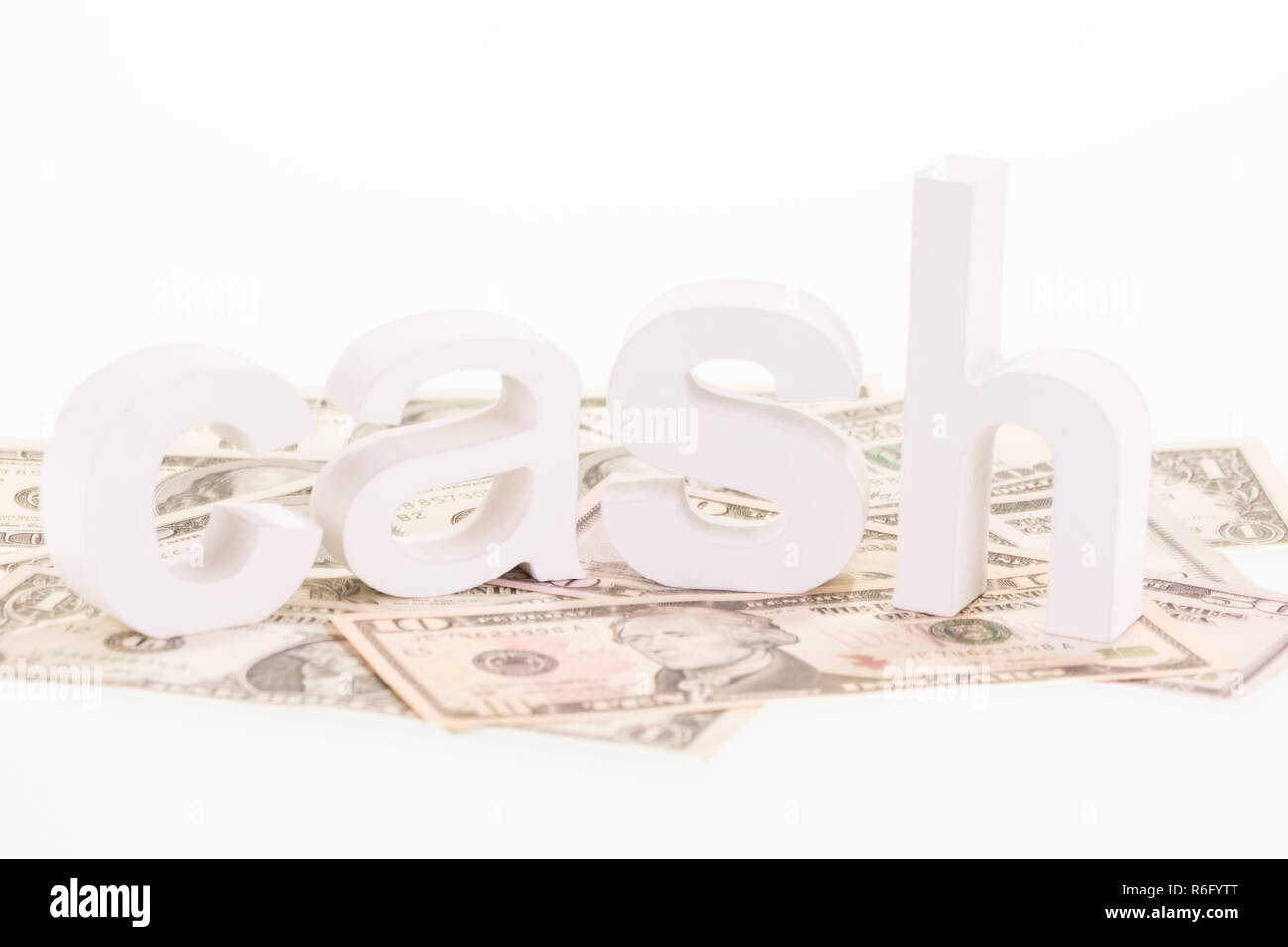 Cash wooden letters and US banknotes Stock Photo - Alamy