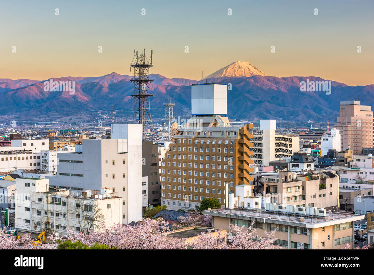 Kofu, Japan city skyline with Mt. Fuji peaking over the mountains at ...