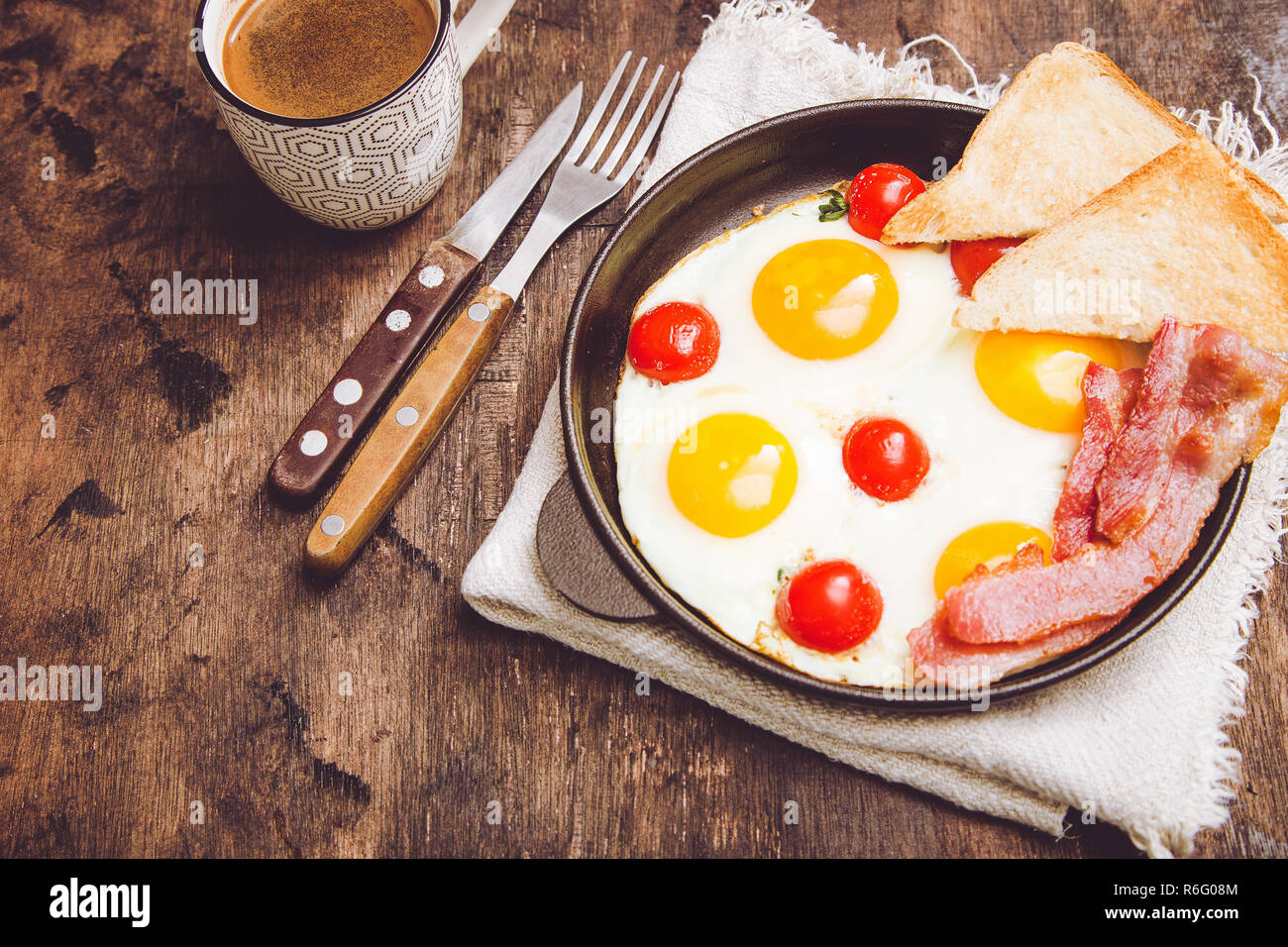 breakfast with eggs, cherry tomatoes, bacon and fresh toasted toast ...