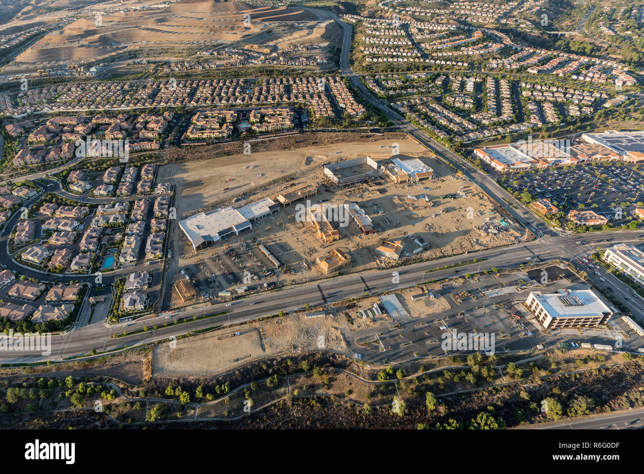 Aerial late afternoon view of homes, shopping center construction and ...