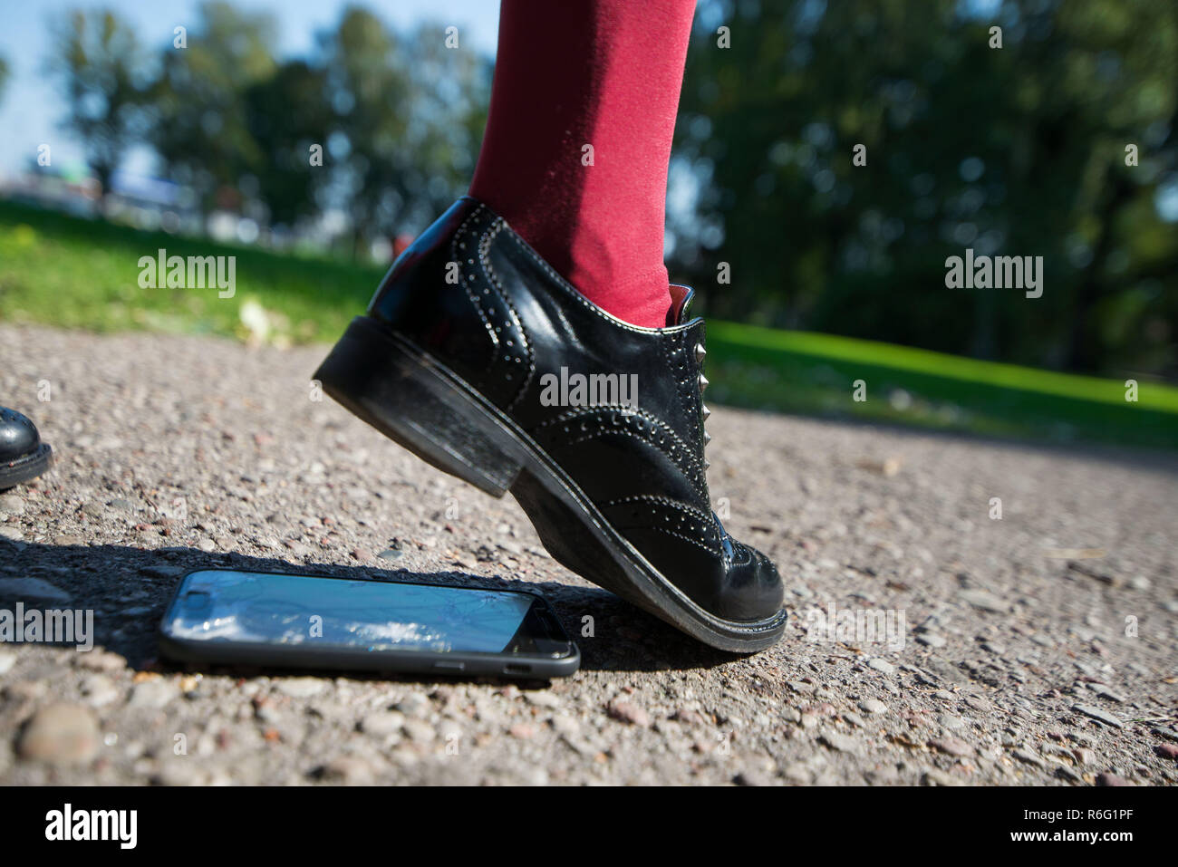 Woman step on the phone. Broken and damaged smartphone with cracks on ...