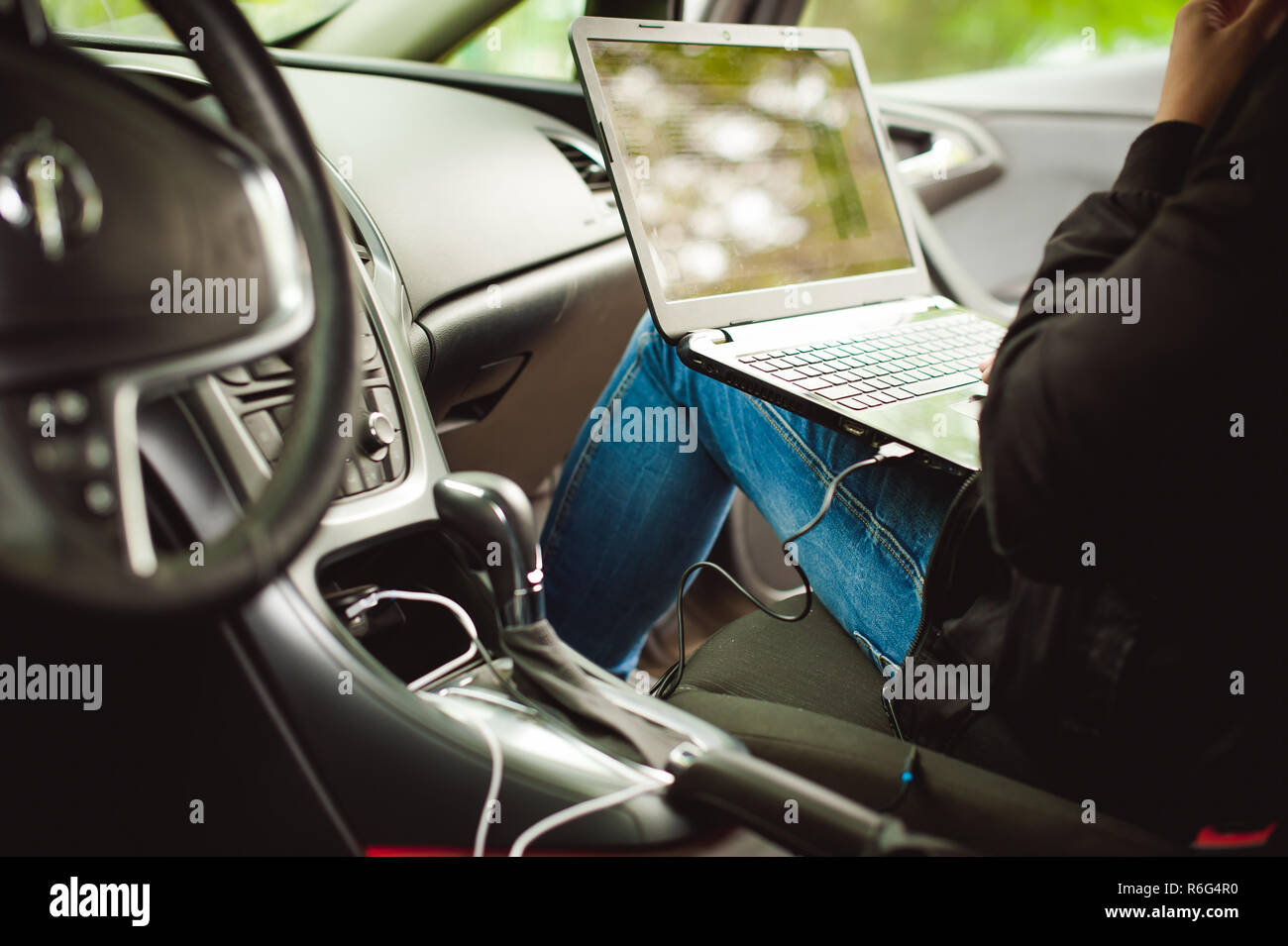 Professional man with a laptop in car tunes tuning control system ...
