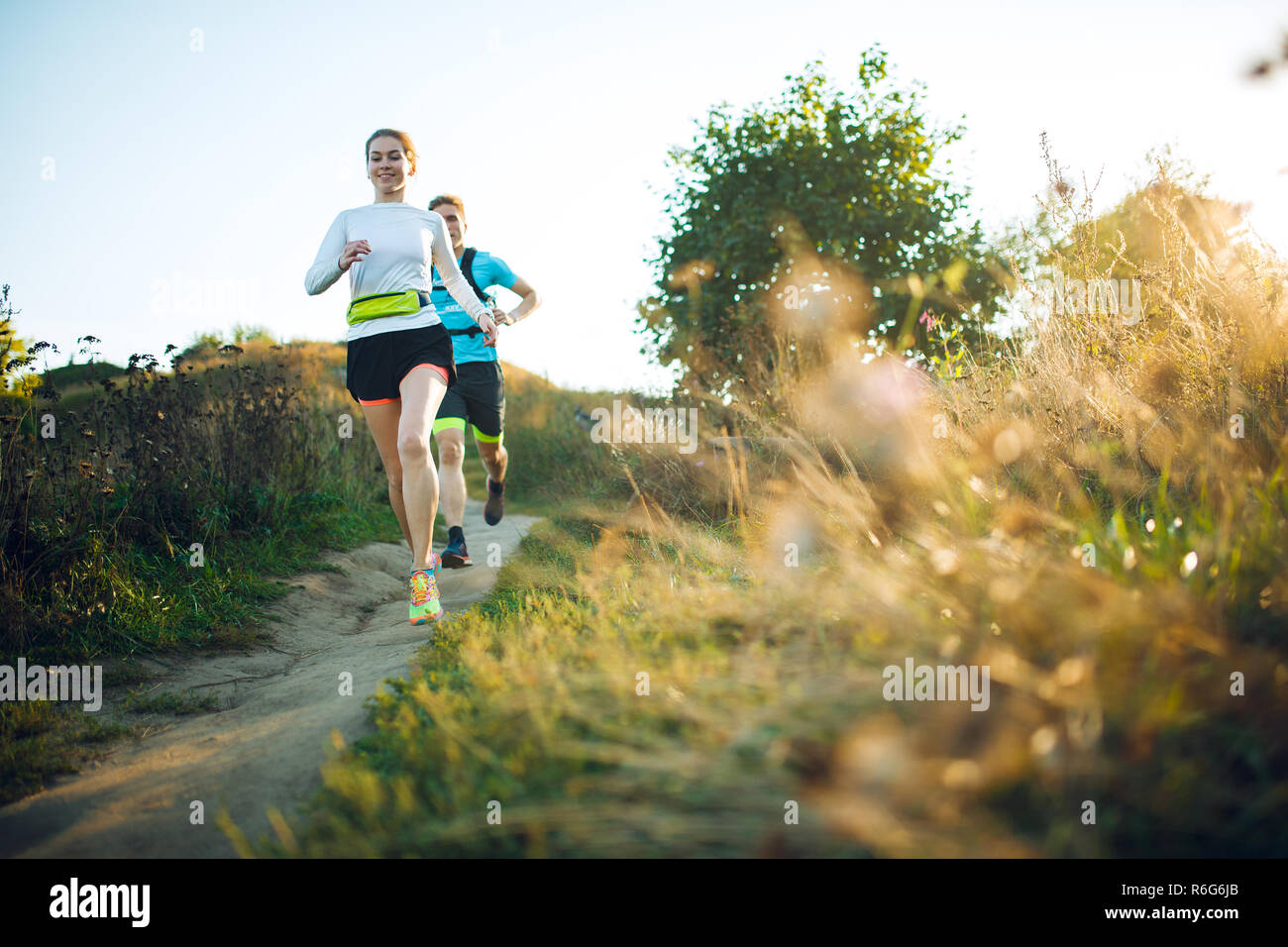 Front photo of sporty woman and man running through park Stock Photo ...