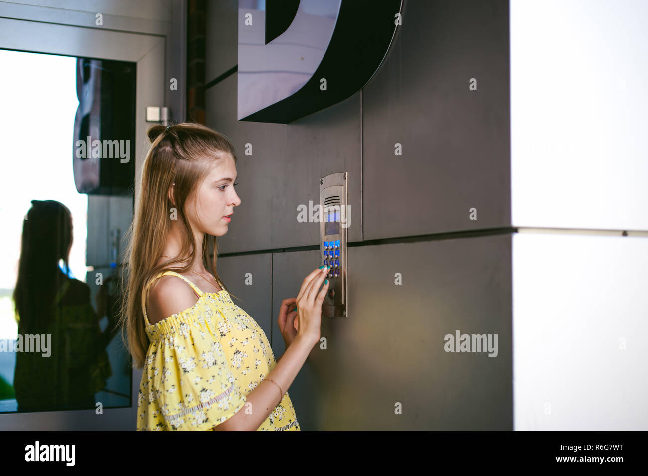 woman dials an apartment code on an electronic doorphone panel Stock ...