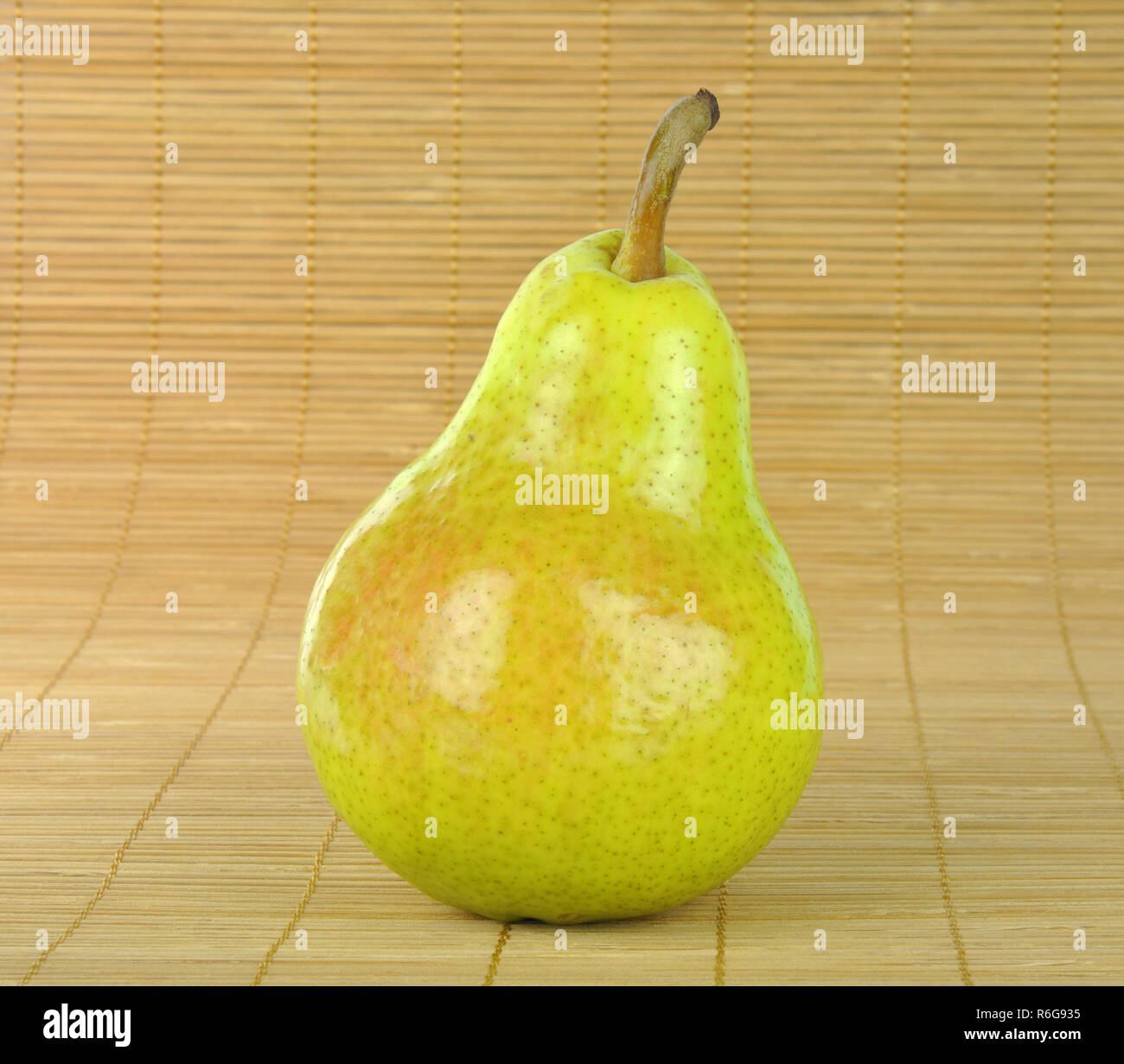 Green pear on bamboo mat background Stock Photo - Alamy