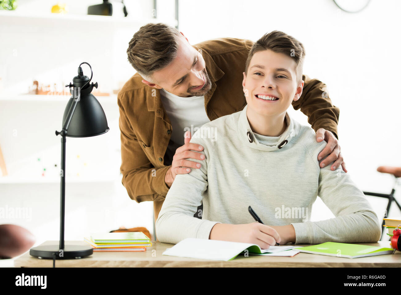 Teen boy doing homework with dad hi-res stock photography and images ...