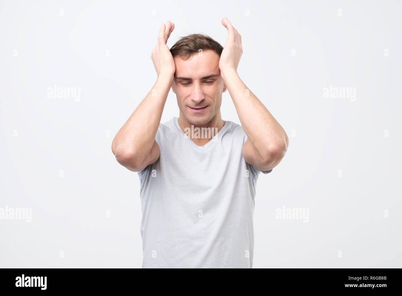 Upset unhappy young italian man squeezing head with hands, suffering ...