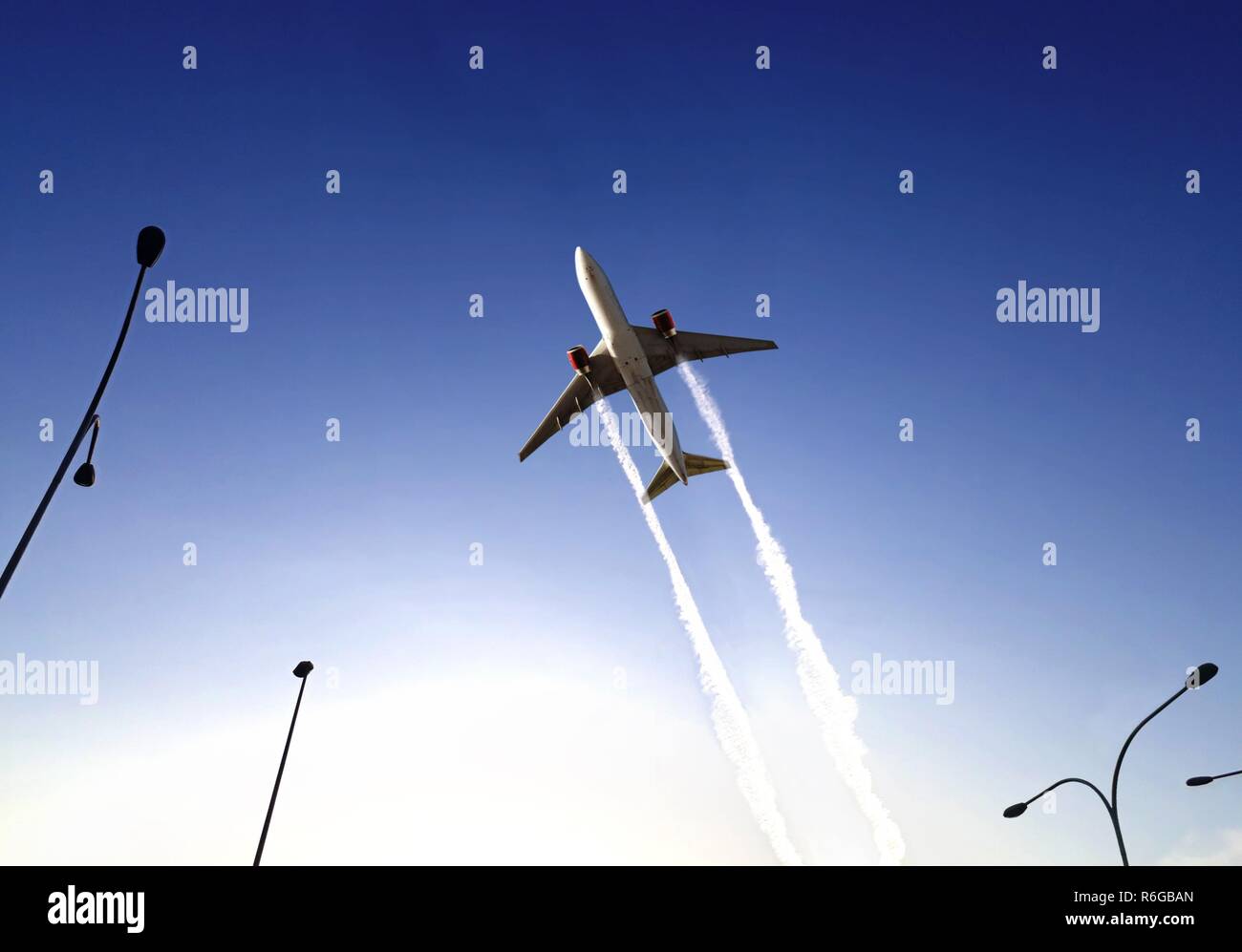 Airplane flying with turbine smoke trail Stock Photo - Alamy