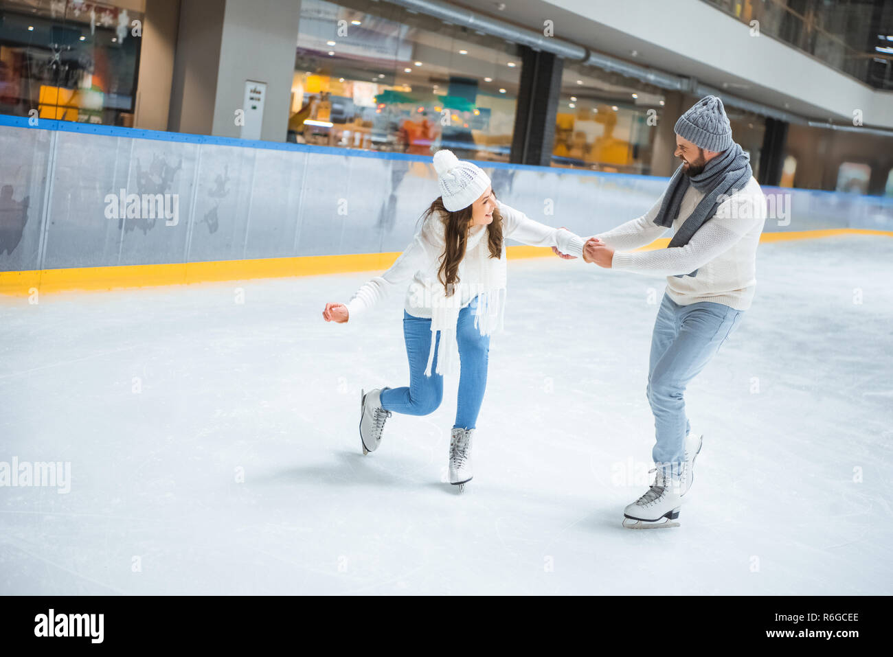 man teaching girlfriend how to skate on ice rink Stock Photo - Alamy