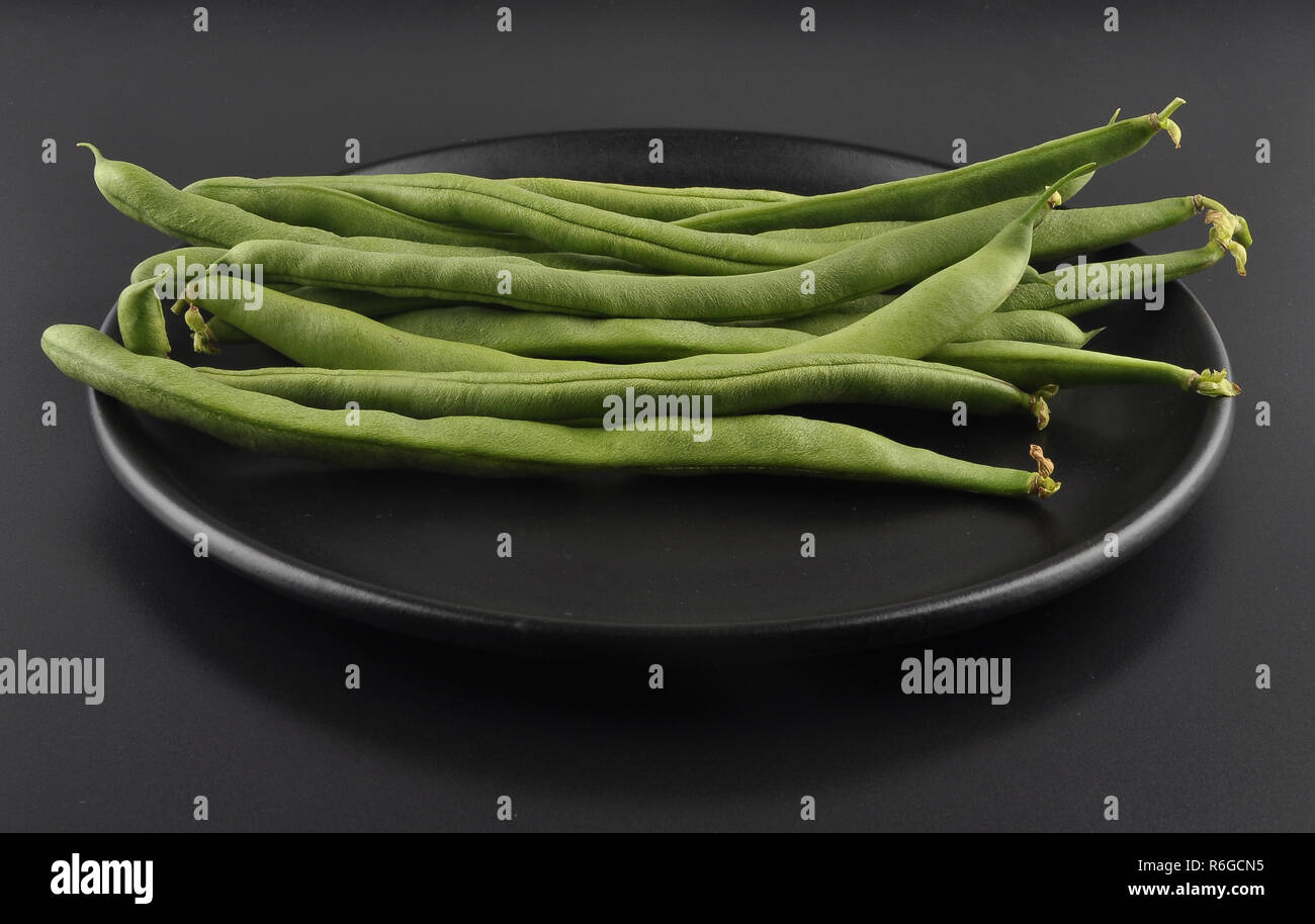 beans on plate and black background Stock Photo - Alamy