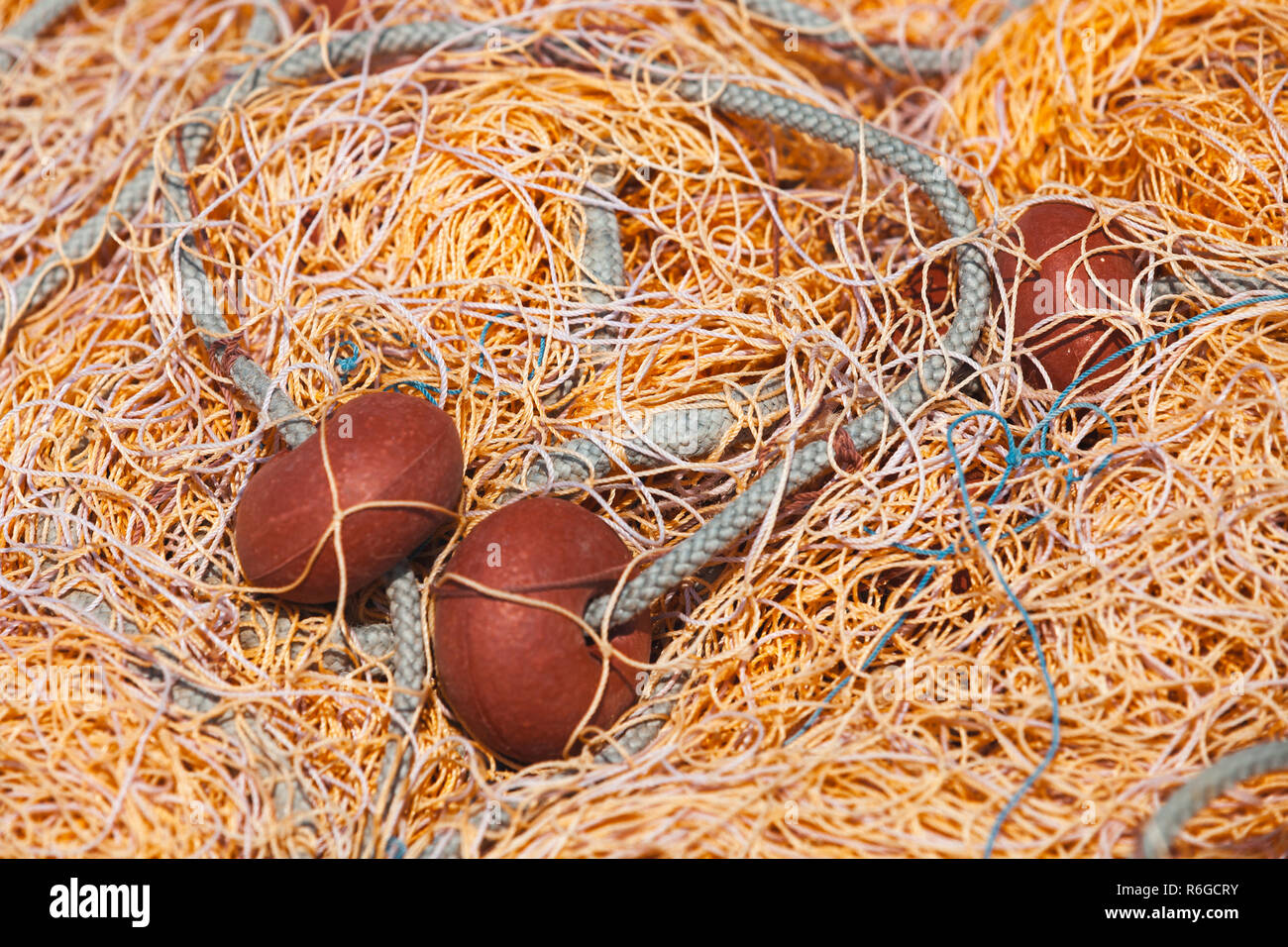 Yellow fishing net with red floats lays in port. Close-up background ...