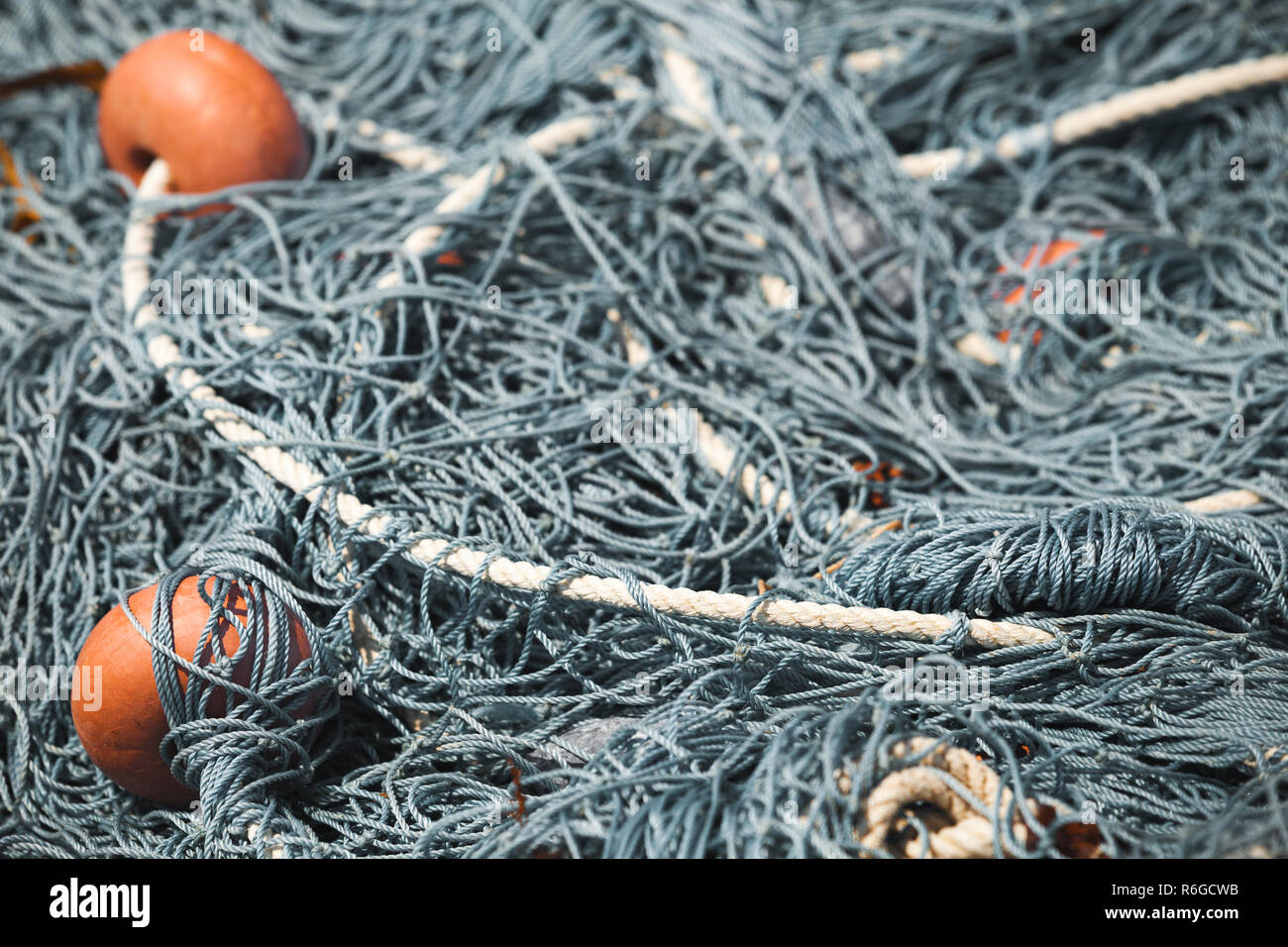 Fishing nets with red floats lay in port. Close-up background photo ...