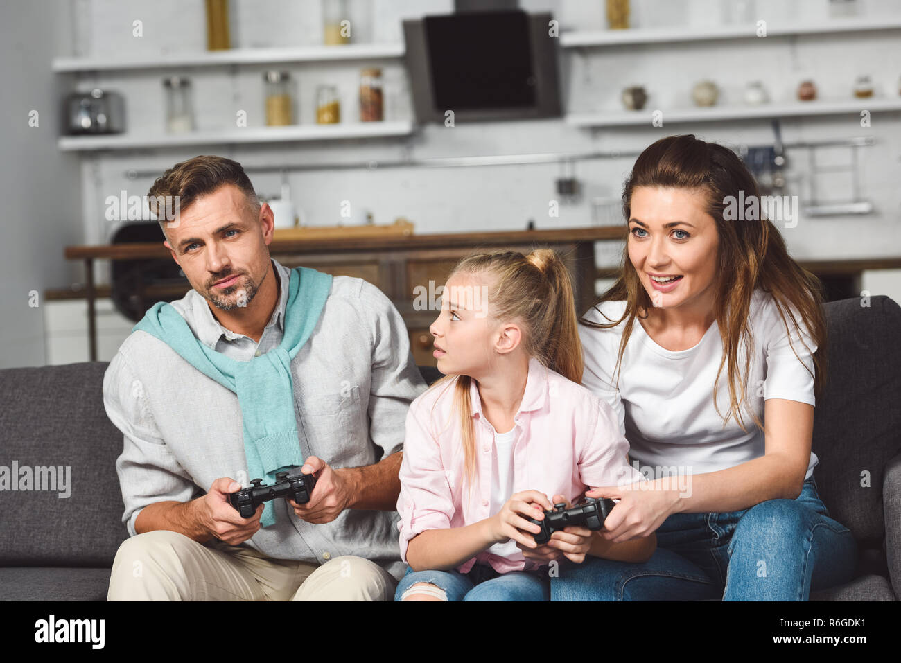 cheerful family spending time together and playing video game with ...