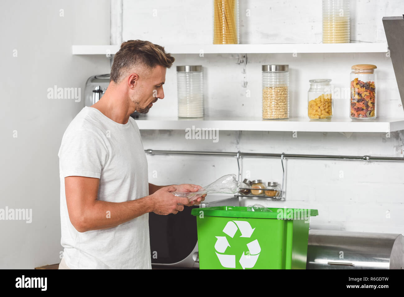 adult man putting empty plastic bottle in green recycle box Stock Photo ...