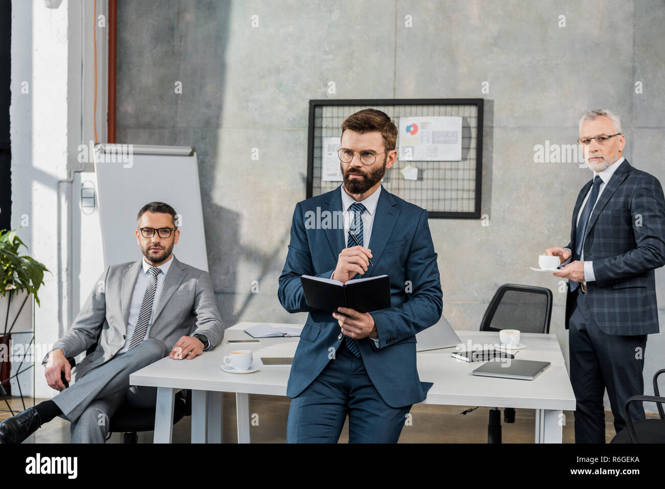 three professional businessmen in formal wear working together in ...