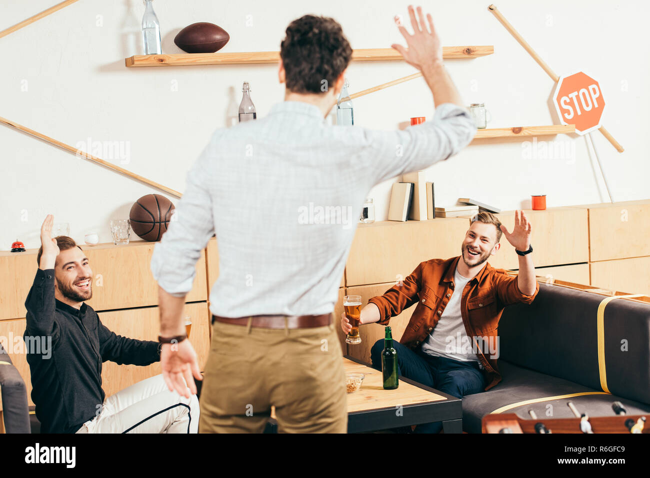 smiling friends greeting each other in cafe Stock Photo - Alamy