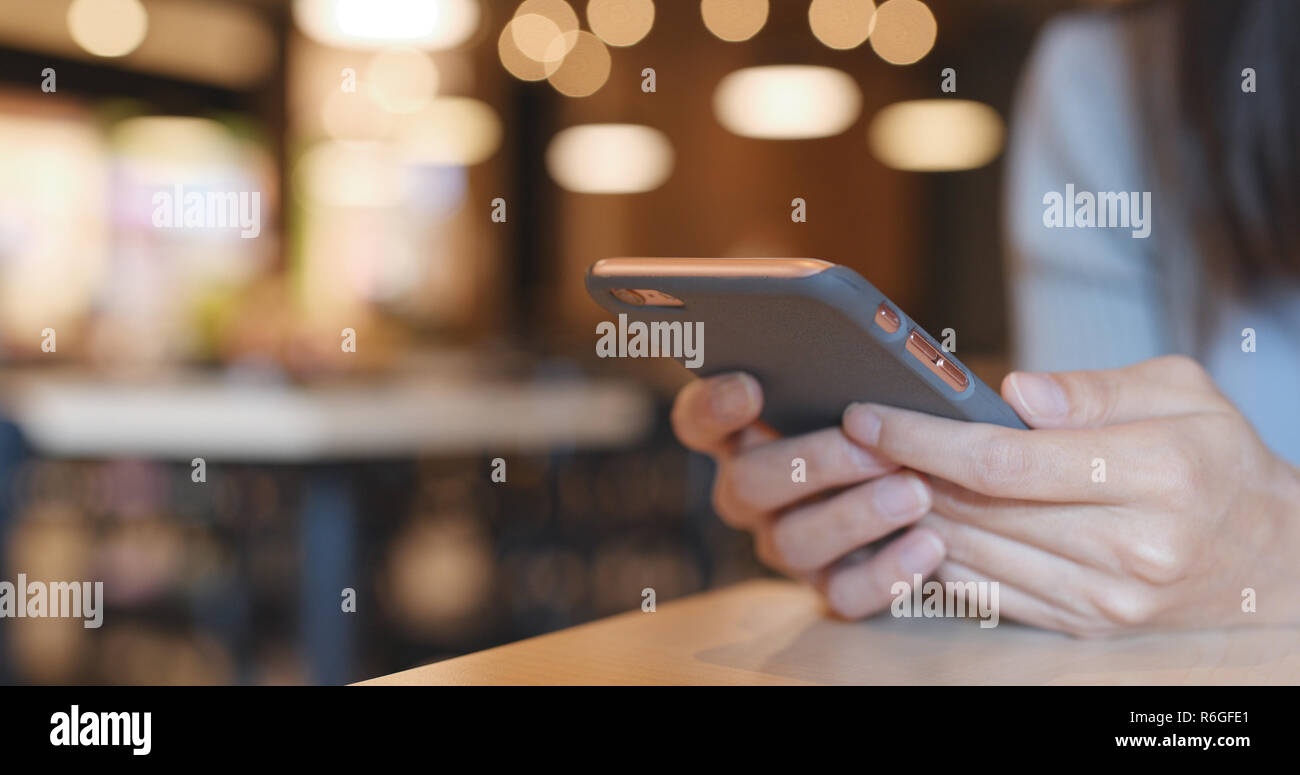 Using cellphone in coffee shop Stock Photo - Alamy