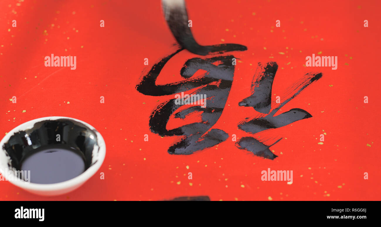 Writing Chinese calligraphy with word meaning lucky Stock Photo - Alamy