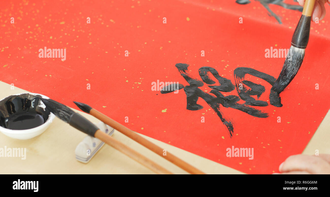 Writing Chinese calligraphy with word meaning luck Stock Photo - Alamy
