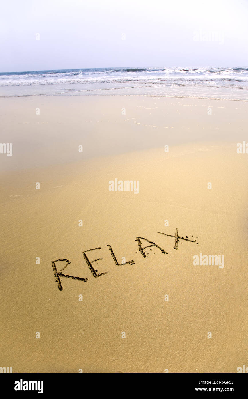 Handwriting word Relax written on the sand Stock Photo - Alamy