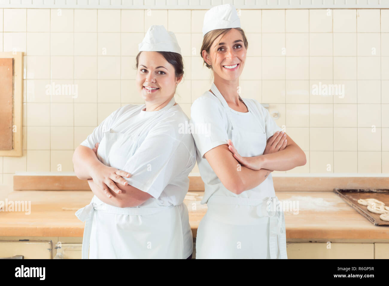Two baker women standing proud in their bakery Stock Photo - Alamy