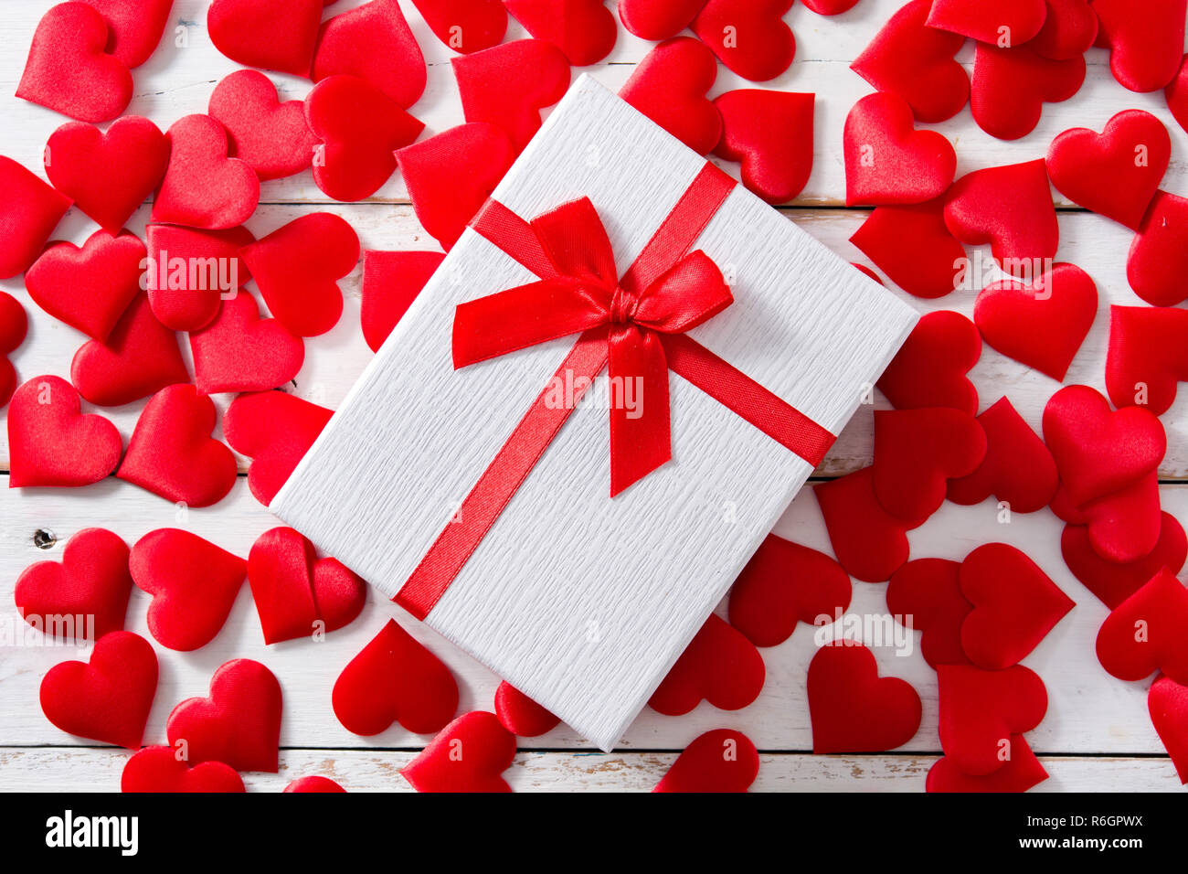 Red hearts and gift box on white wooden background. Top view Stock ...