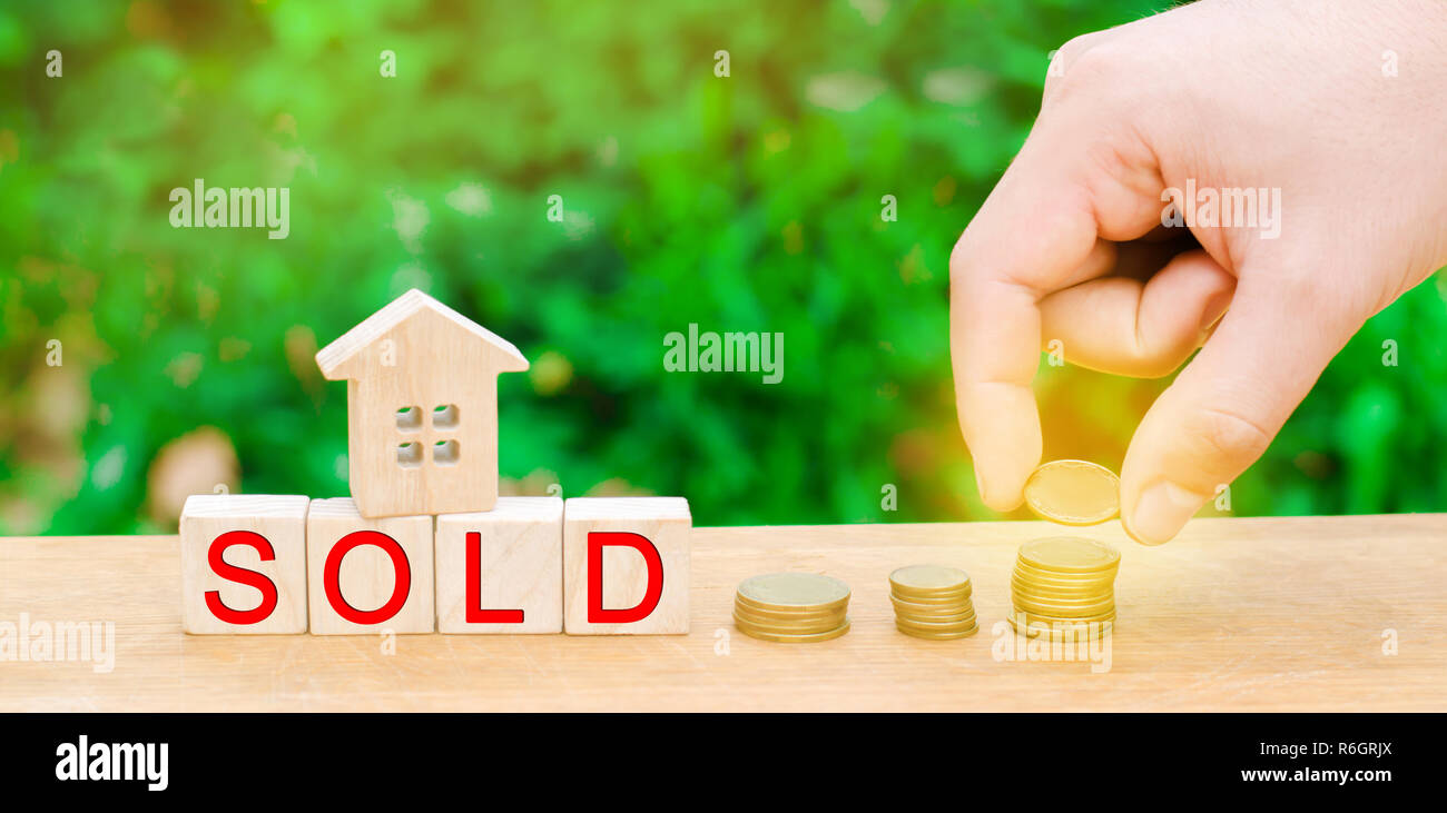 wooden house and coins with the inscription "sold". sale of property ...