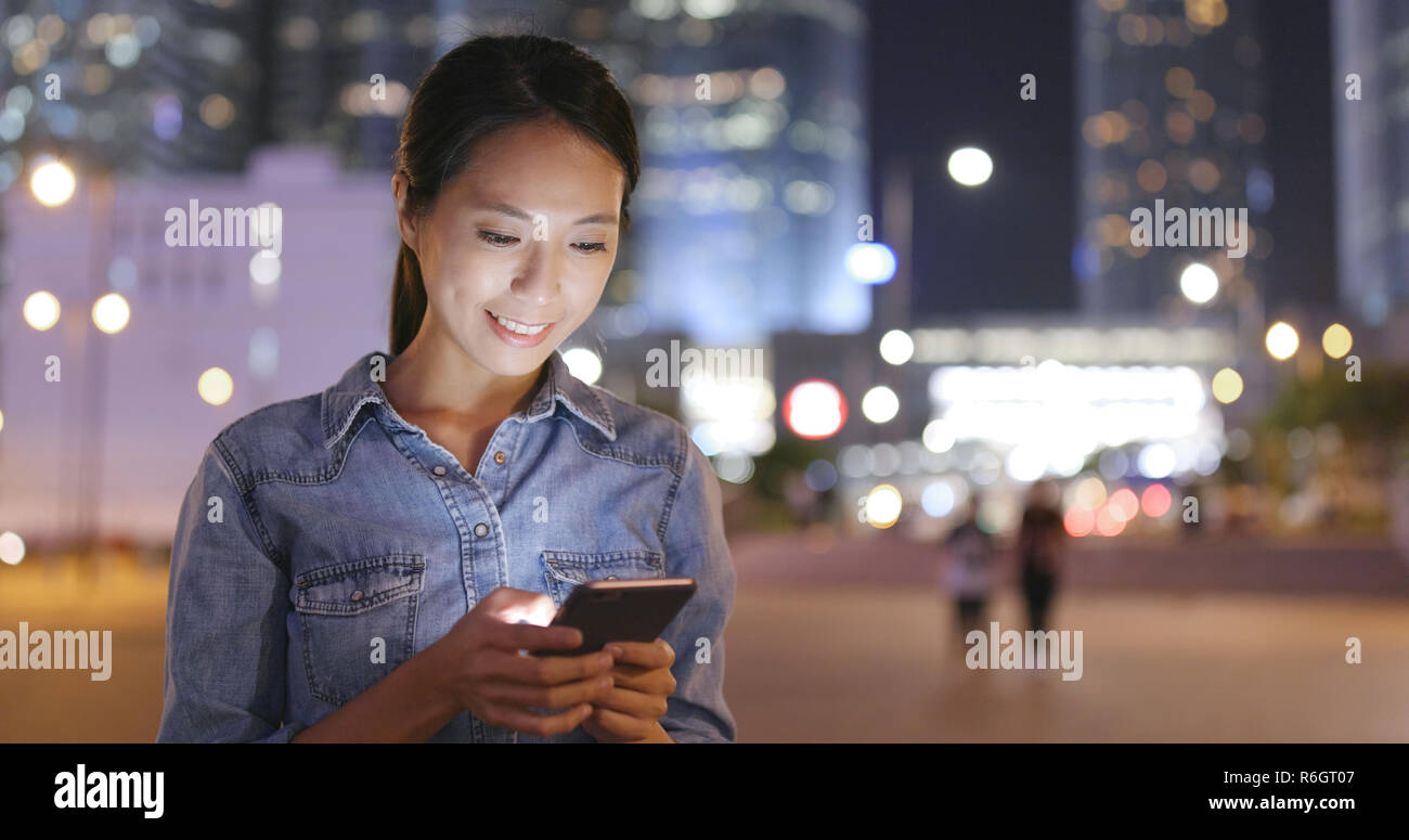 Woman use of mobile phone in Hong Kong at night Stock Photo - Alamy