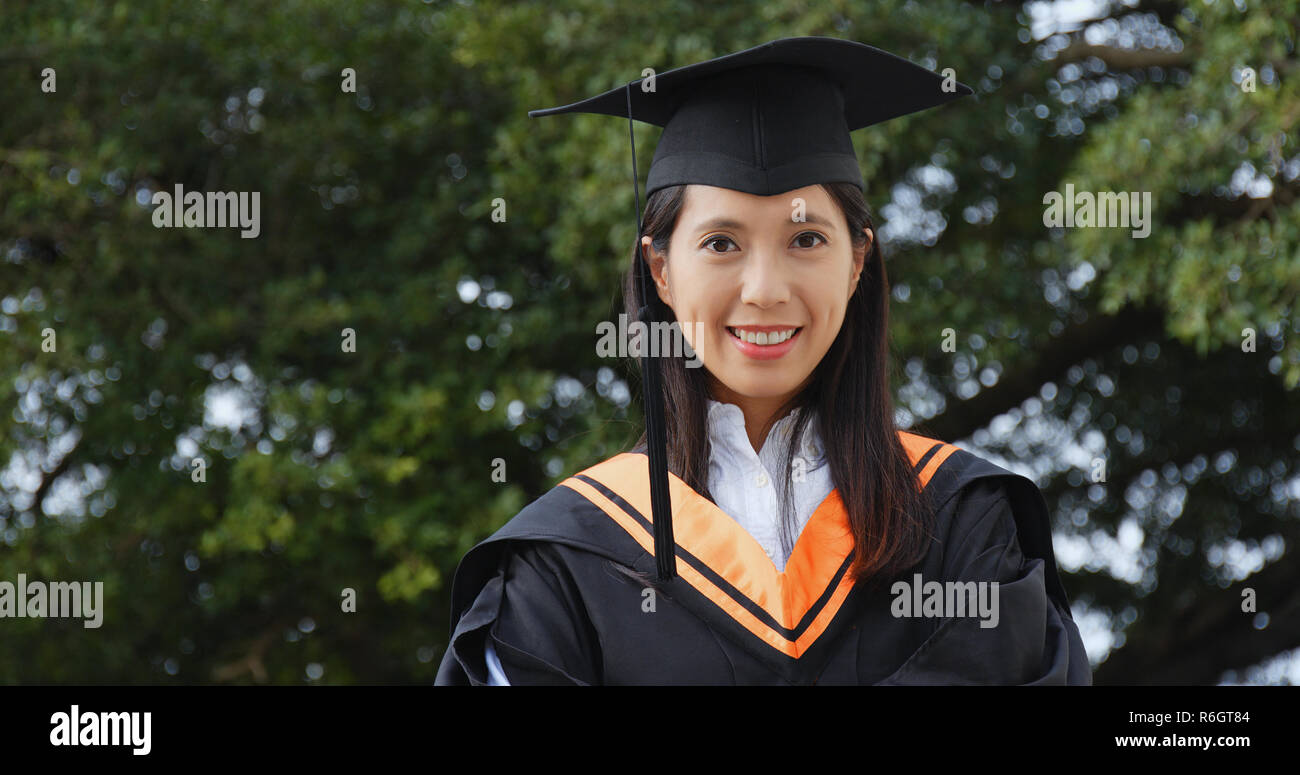 Asian woman wearing graduation gown Stock Photo - Alamy