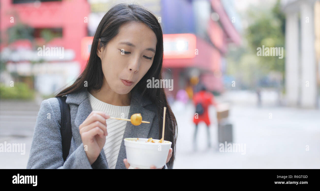 Woman eating fish ball, Hong Kong style snack Stock Photo - Alamy
