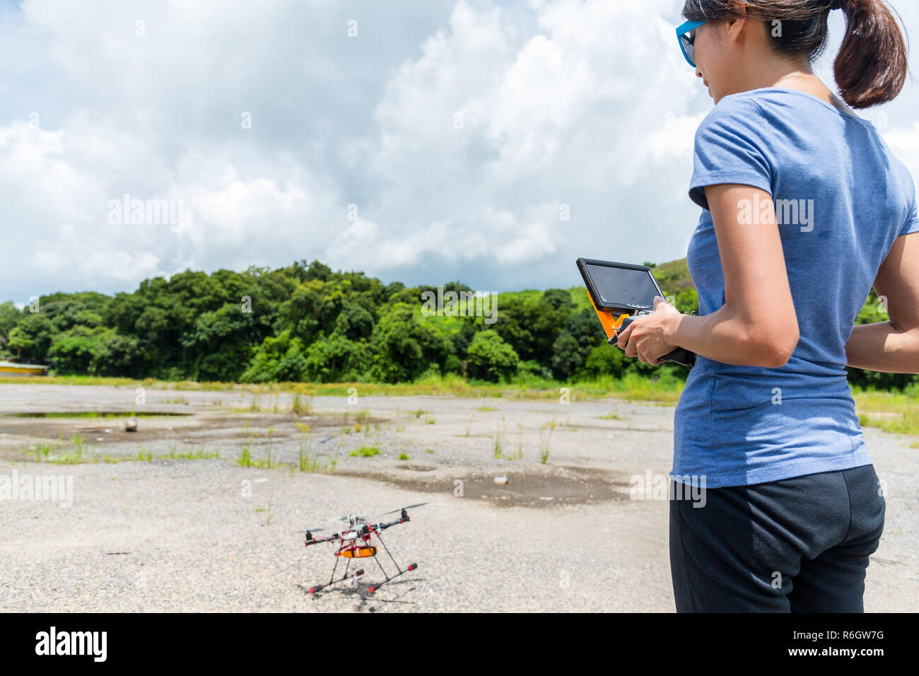 Woman control with flying drone Stock Photo - Alamy