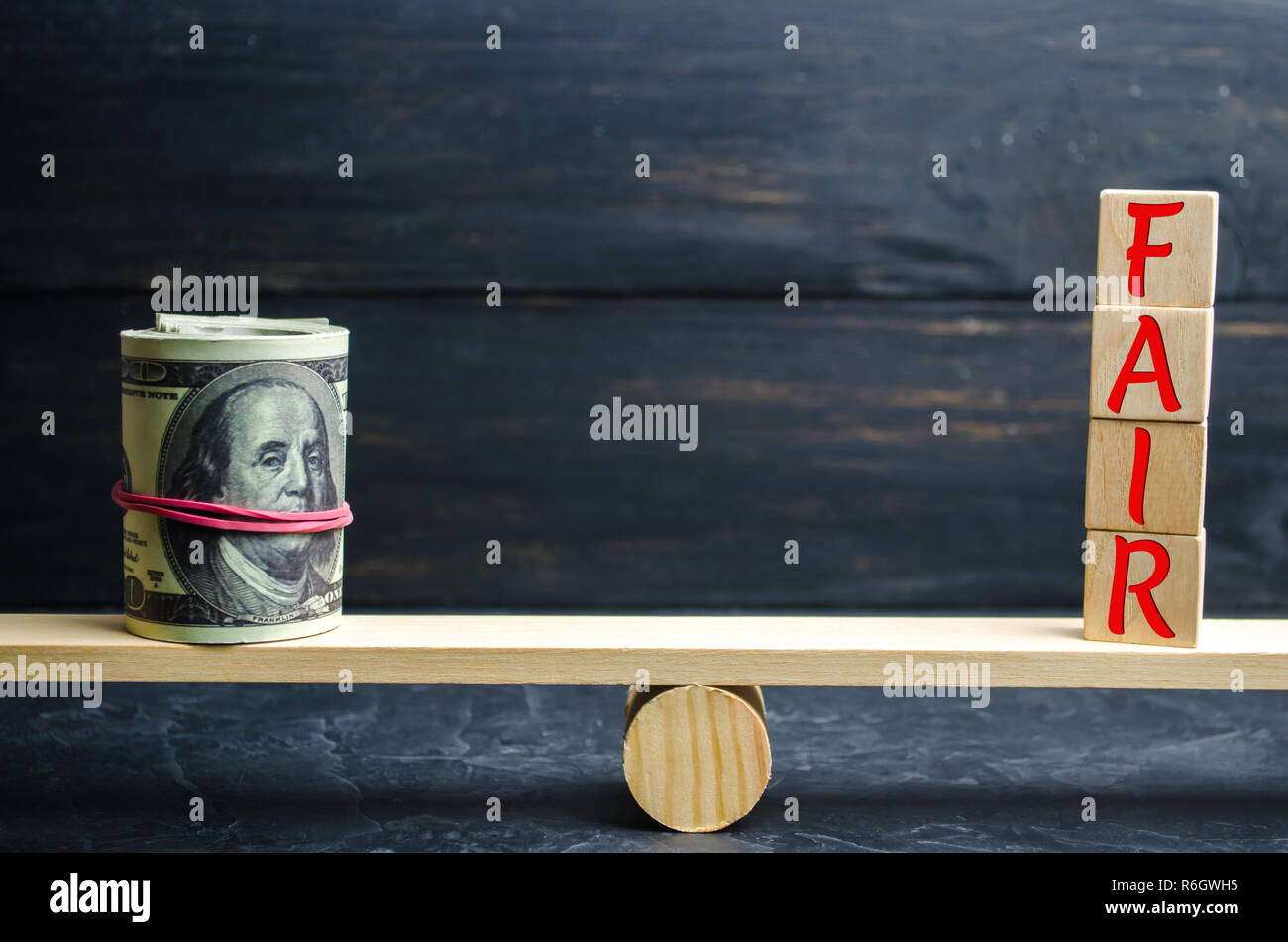 Dollars and the inscription "Fair" on wooden blocks. Balance. Fair ...