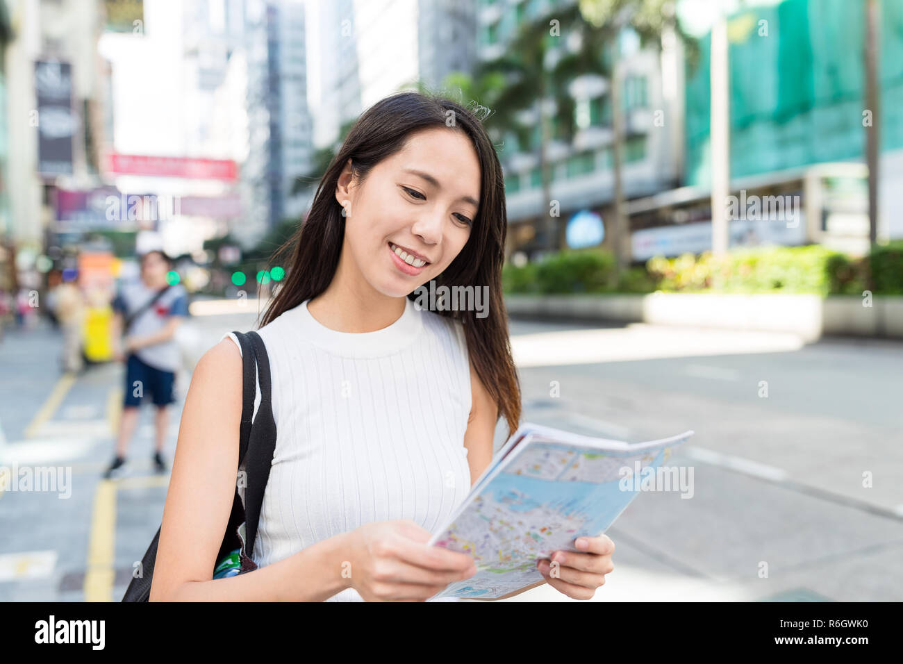 Woman looking for direction on map Stock Photo - Alamy