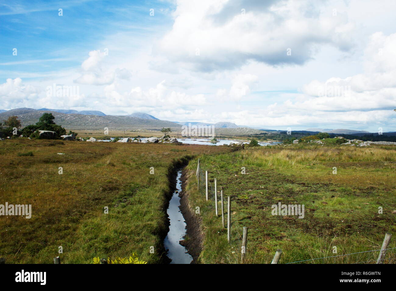 Landscape with stream and fence Stock Photo - Alamy