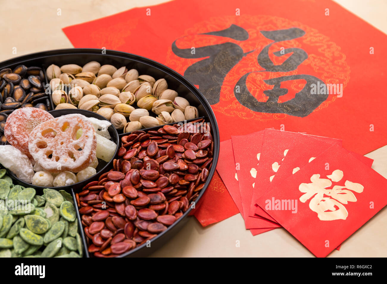 Traditional Chinese snack tray with red packet and Chinese calligraphy ...