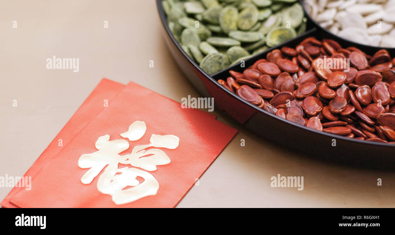Traditional chinese snack tray with red packet of word meaning luck ...